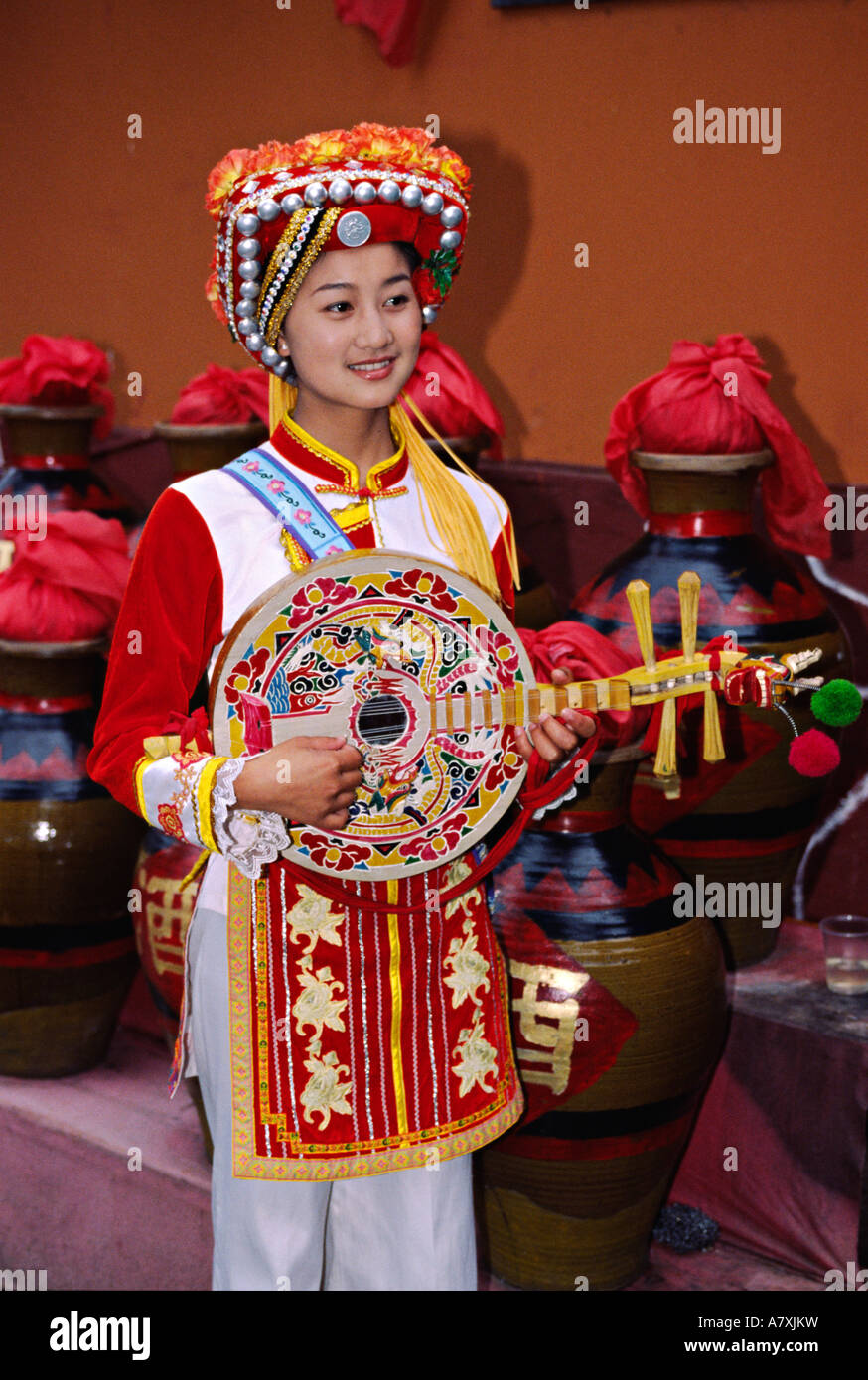 Asia, China, Yunnan Province. Young Yi ethnic minority woman plays ...
