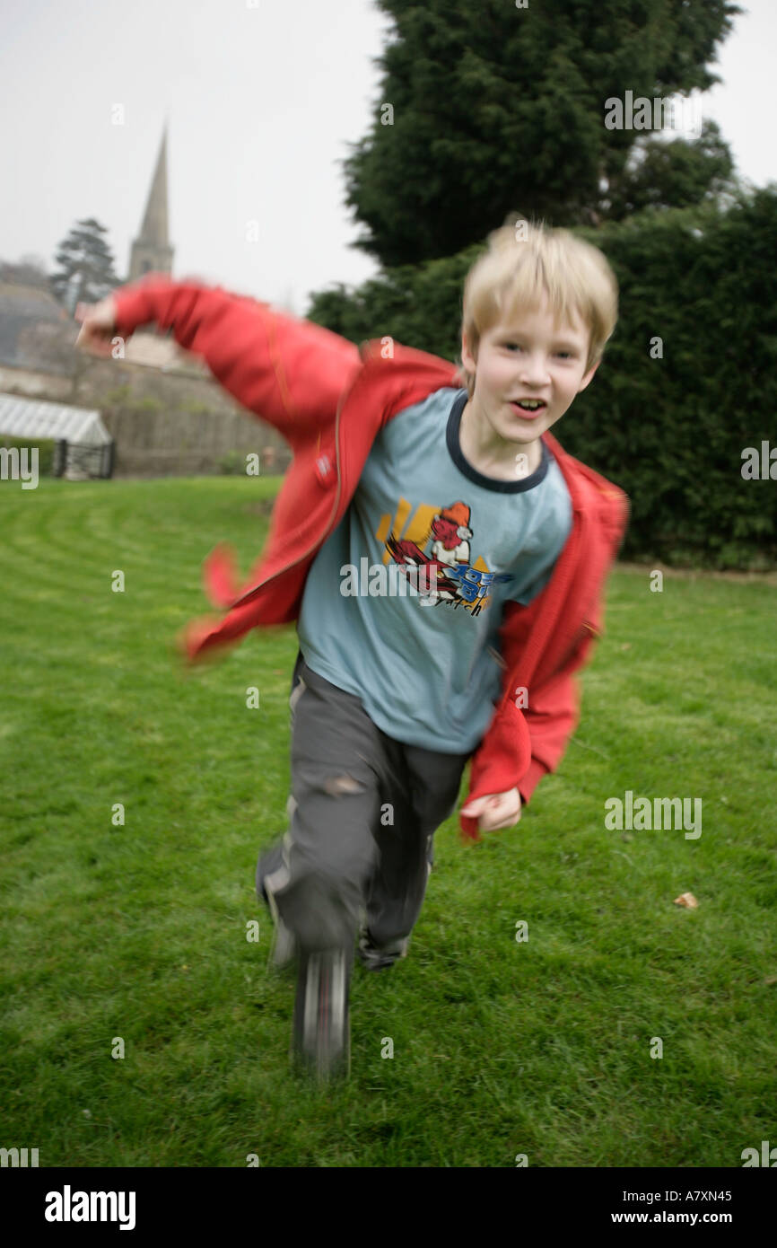 Young boy running in a garden Stock Photo - Alamy