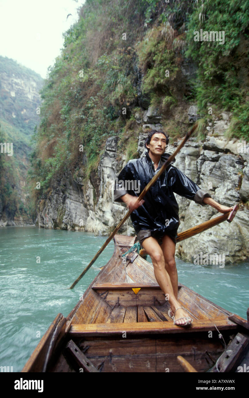 China, Sichuan Province, Wushan, Den Zhu Xian pilots wood canoe in ...