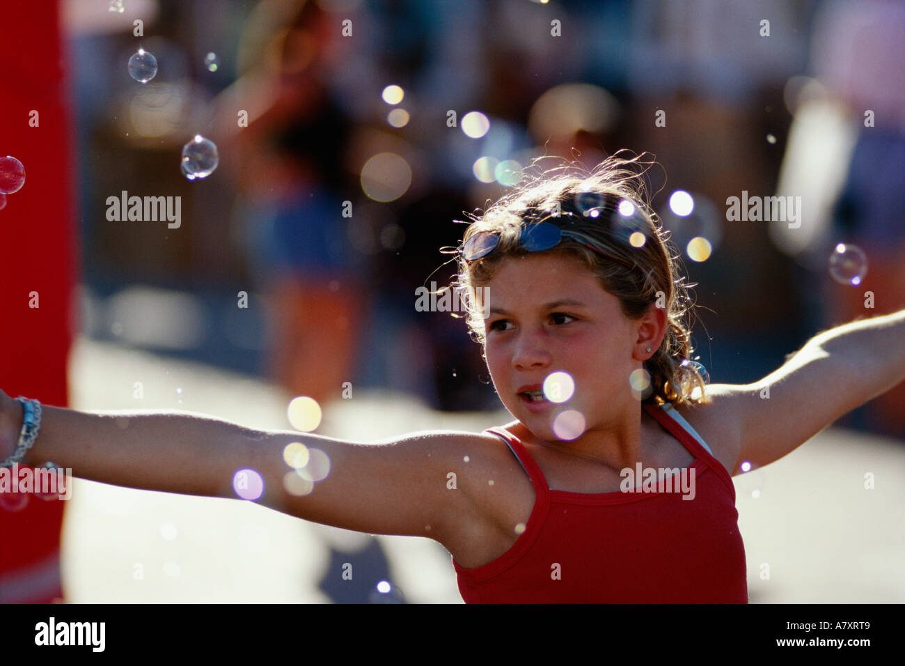Adolescent girl enjoys floating soap bubbles at festival, California ...