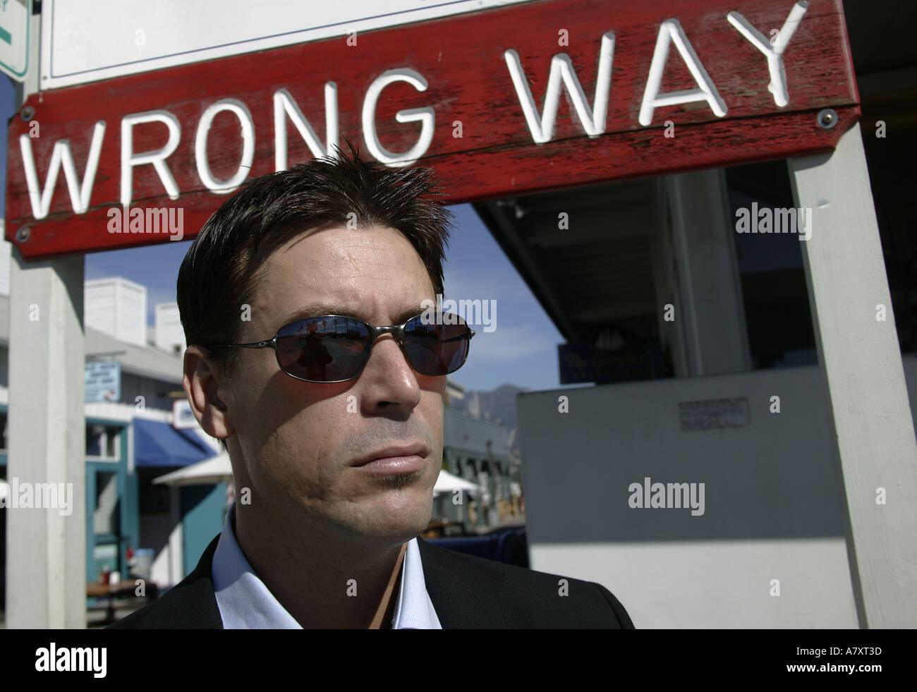 business man wrong way sign direction warning red Stock Photo - Alamy