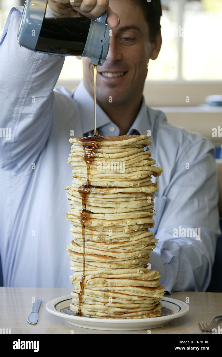 MAN POURING SYRUP OVER HUGE PILE OF PANCAKES Stock Photo - Alamy