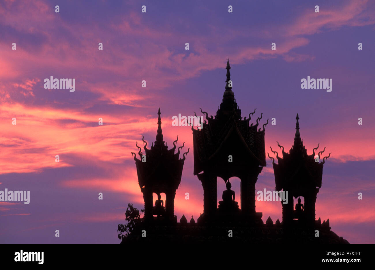 Asia, Laos, Vientiane, Setting sun silhouettes gate outside Pha That ...