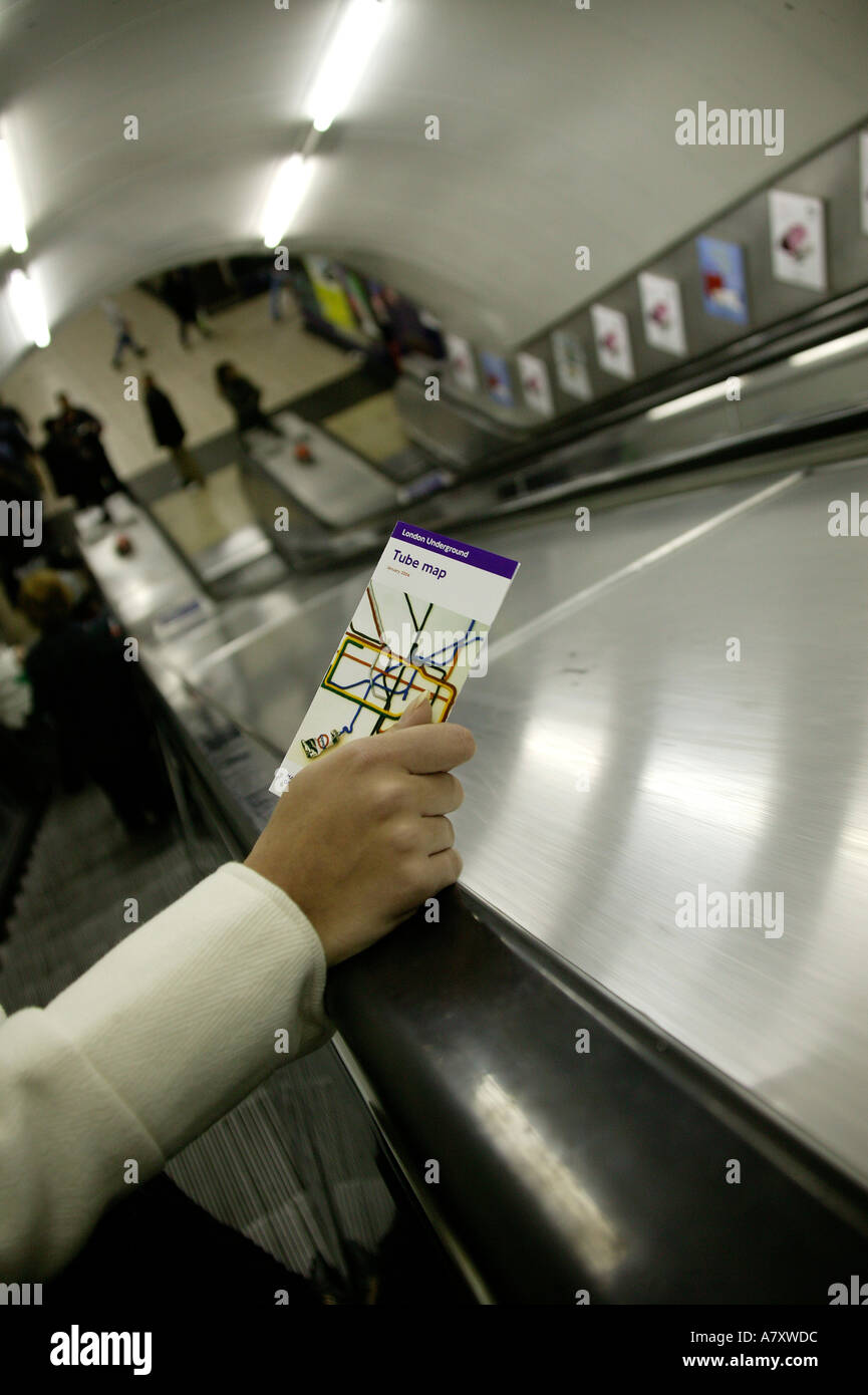 Going down an escalator holding a Tube Map Stock Photo - Alamy