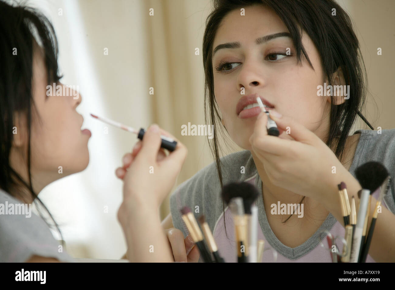 Woman applying makeup Stock Photo - Alamy