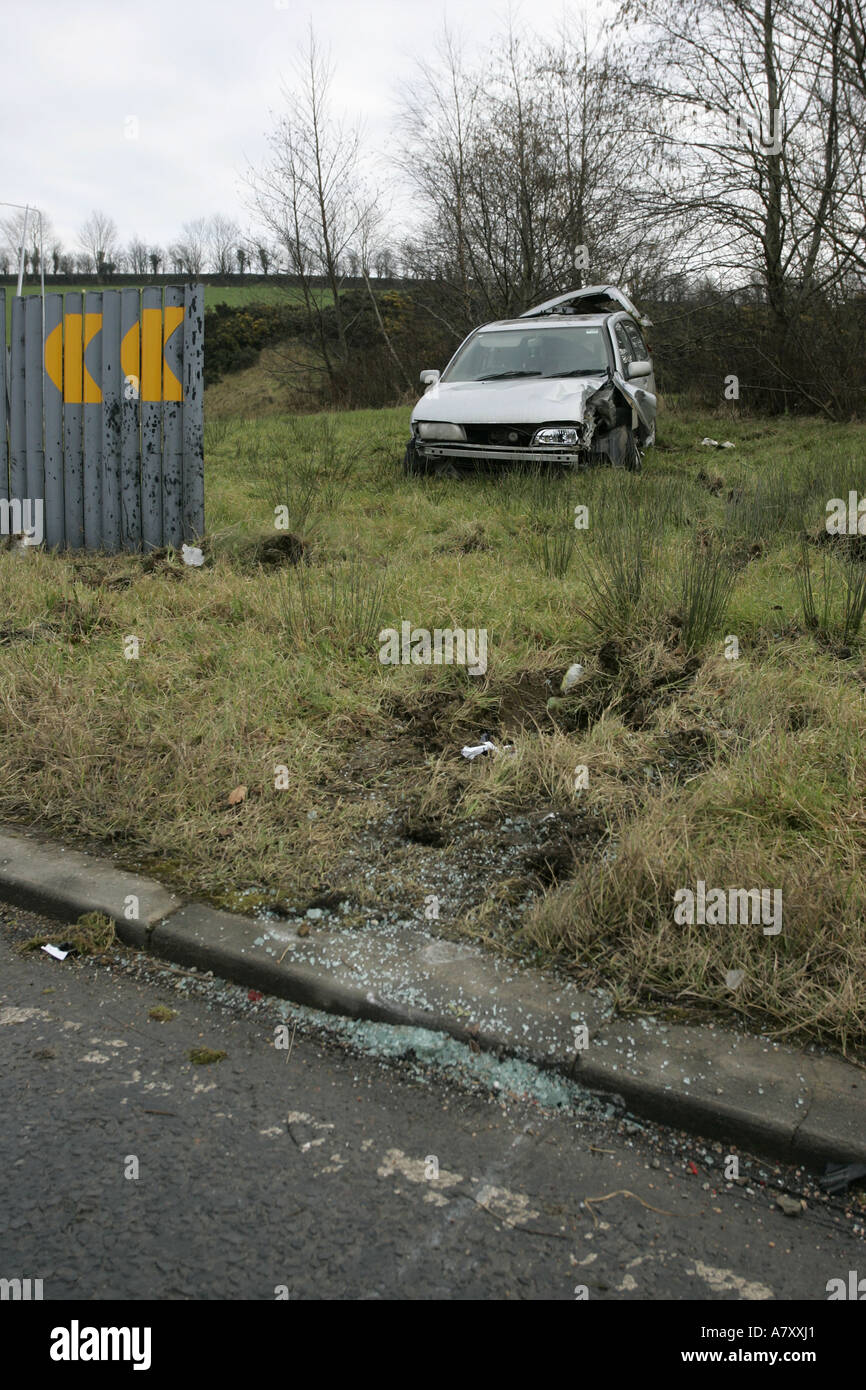 road traffic accident with crashed car and warning sign on a roundabout ...