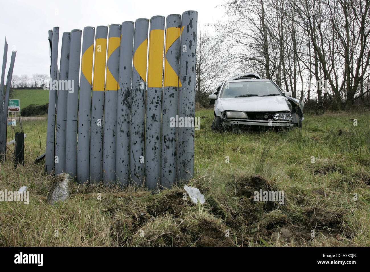 road traffic accident with crashed car and warning sign on a roundabout ...