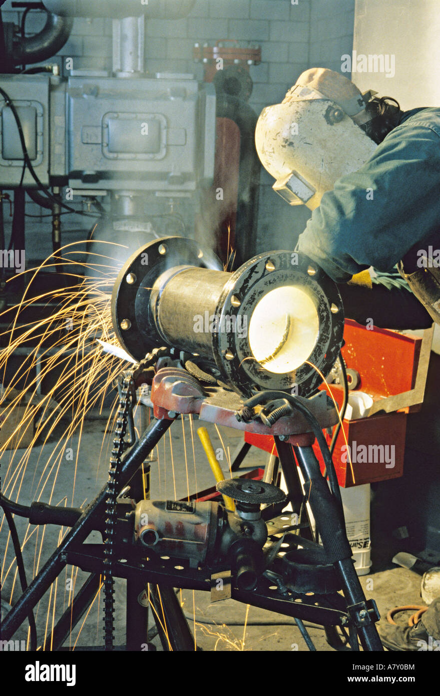 Pipe fitter grinding pipe in factory construction site Stock Photo - Alamy