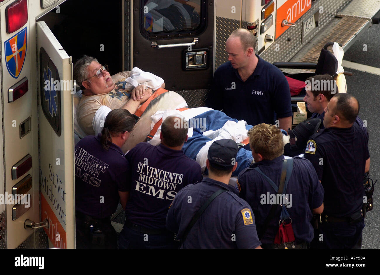 Emergency Medical Workers transfer an obese patient into the ambulance ...