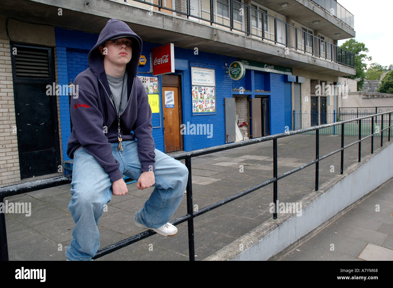 Young boy hanging around the streets dressed in hoodie looking ...