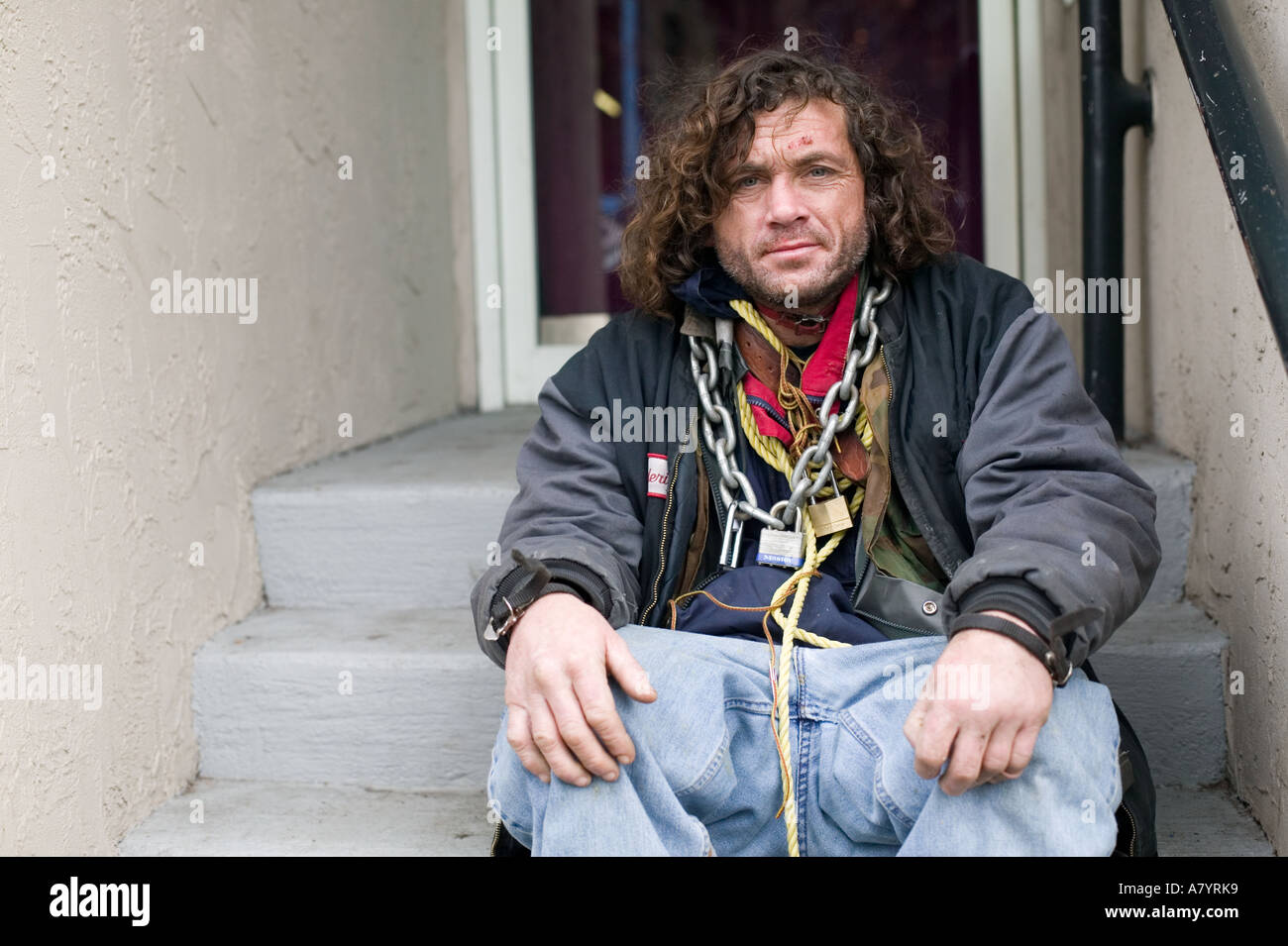 Homeless man with chains and locks Stock Photo - Alamy