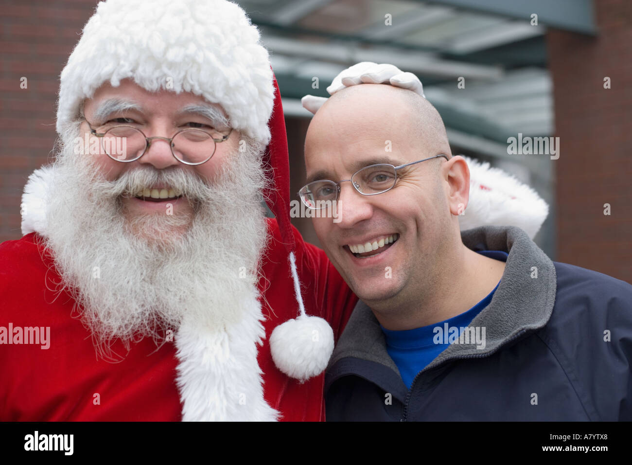santa Claus poses with bald headed man Stock Photo - Alamy