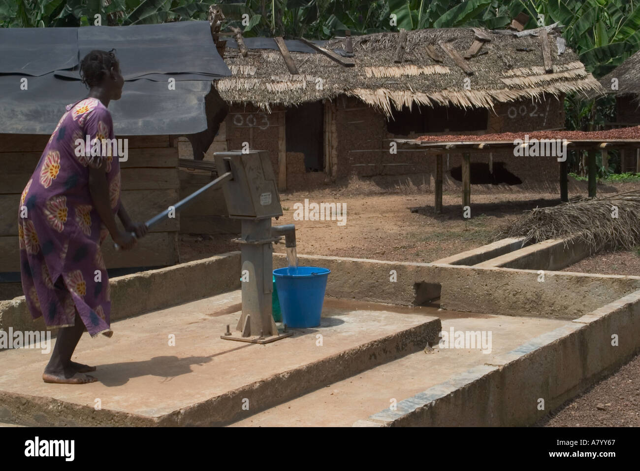 Young woman using hand pump for pumping potable and safe drinking water ...