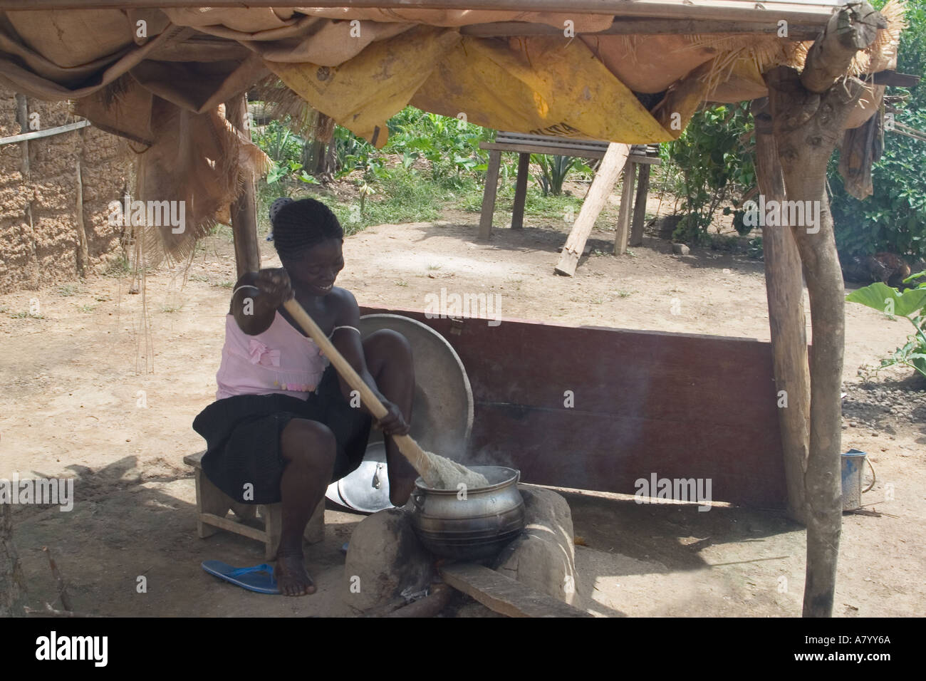 Village woman cooking over a charcoal fire, a Ghanaian food dish Banku ...