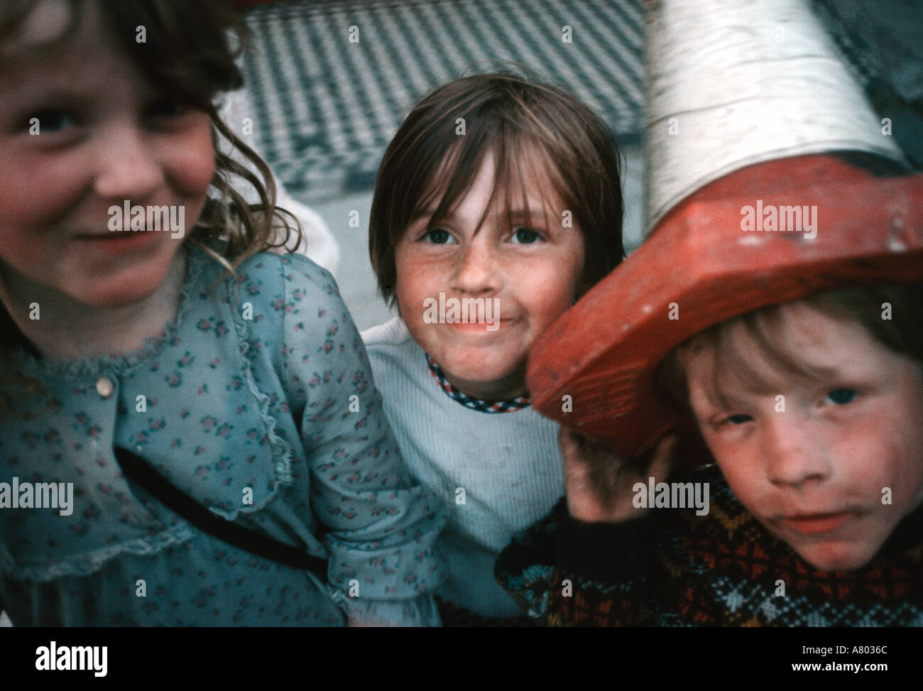 Children with grubby faces playing with a traffic marker cone Stock ...