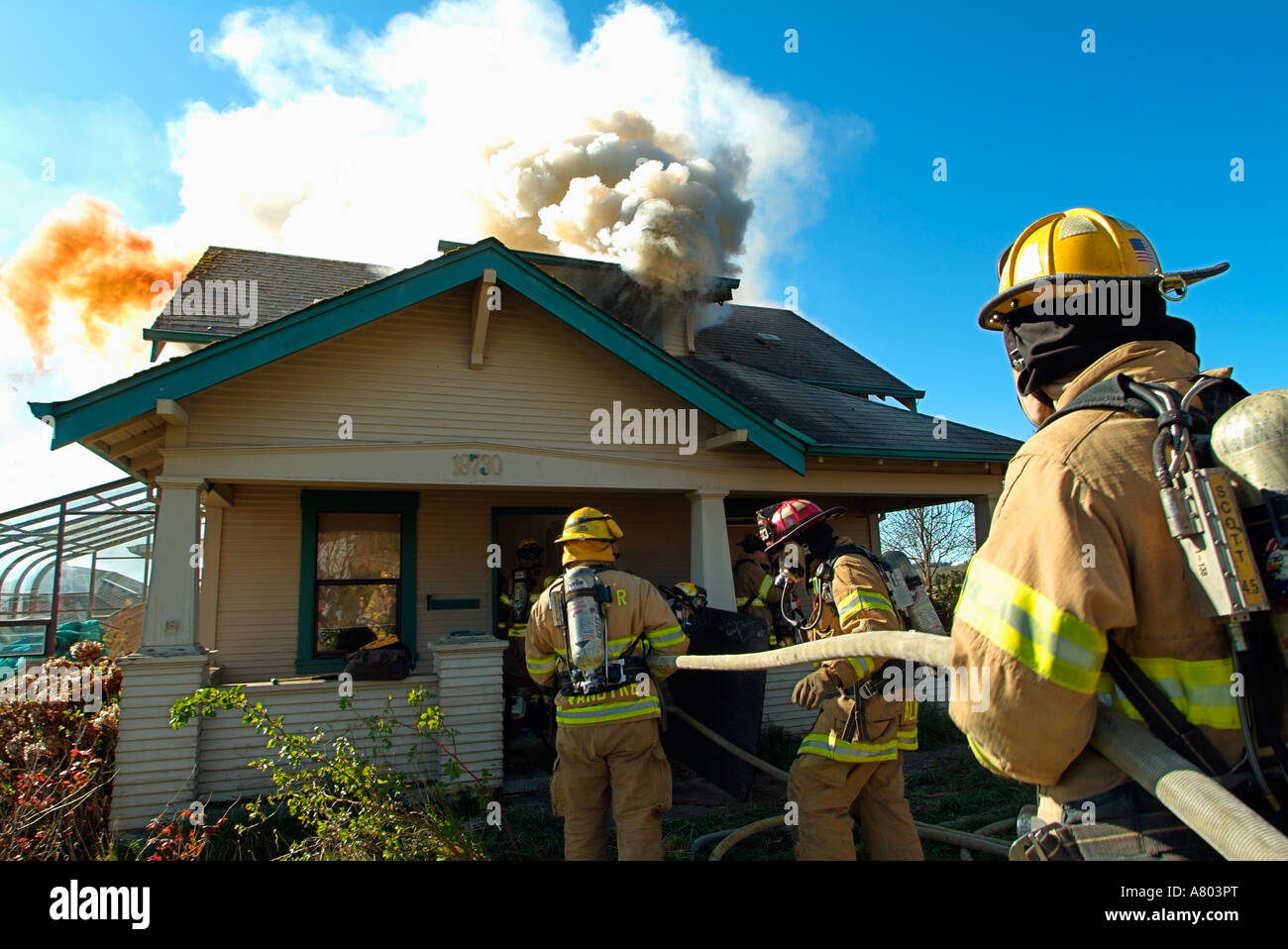 Firefighters from Tualatin Valley Fire and Rescue bring a water hose ...