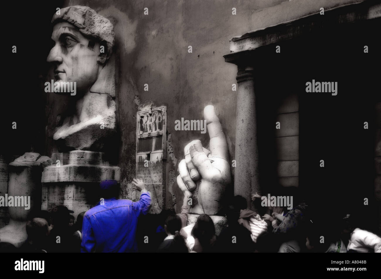 Schoolchildren with teacher looking at fragmented statue of Emperor ...