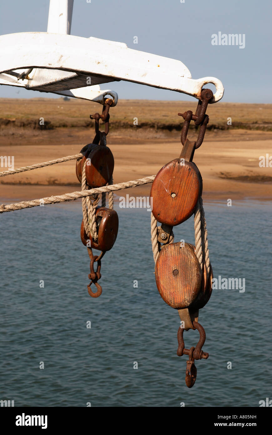 Lifeboat davits and wooden pulley blocks on an old schooner moored at ...