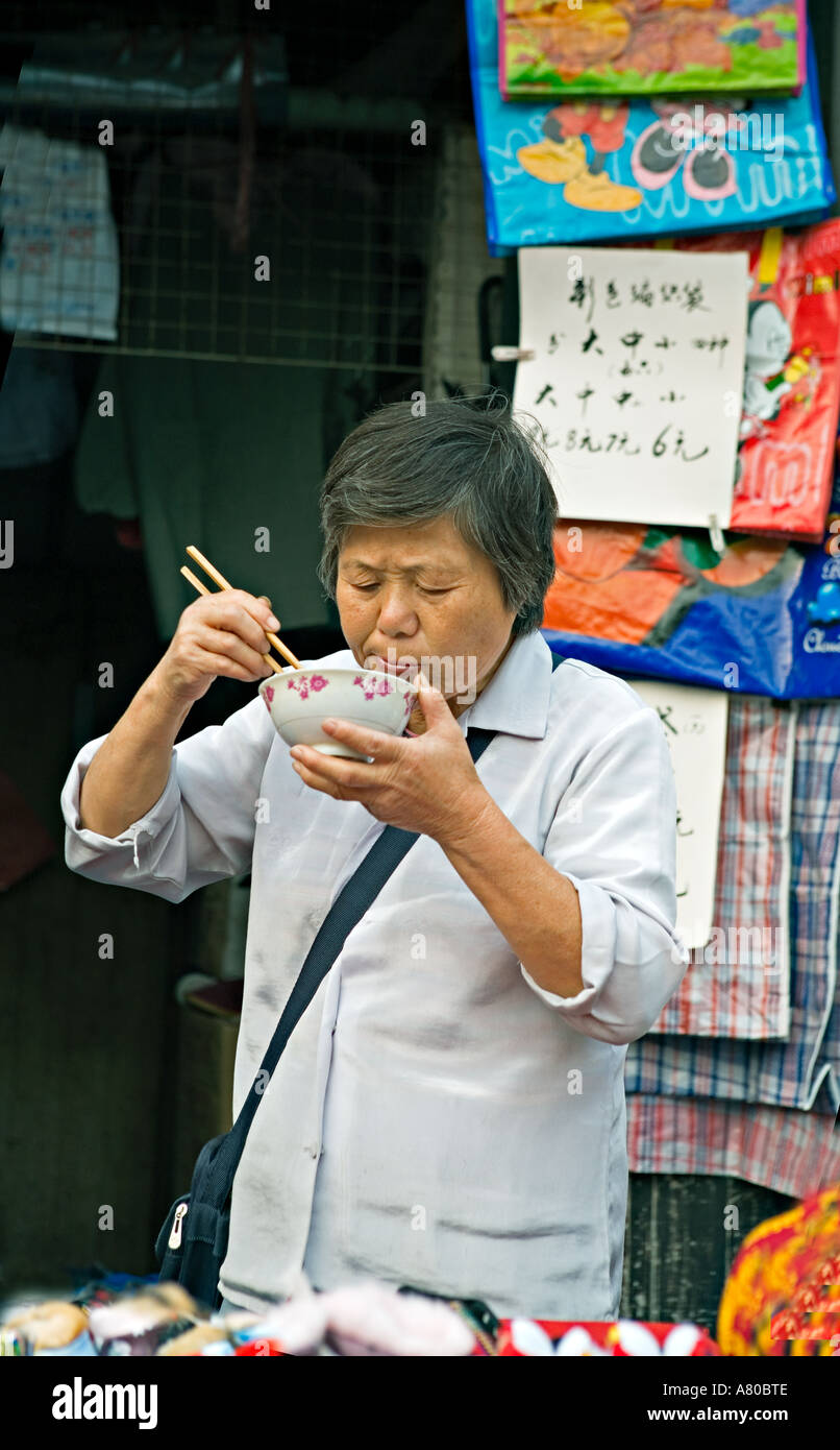 CHINA SHANGHAI Female Chinese merchant eating lunch of noodles Stock ...