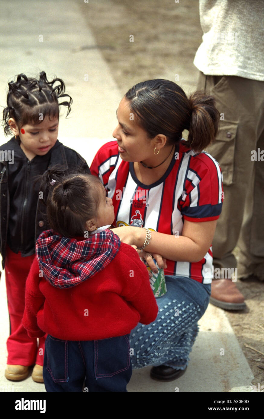 Mother age 23 with children ages 2 and 3 at Cinco de Mayo festival. St ...