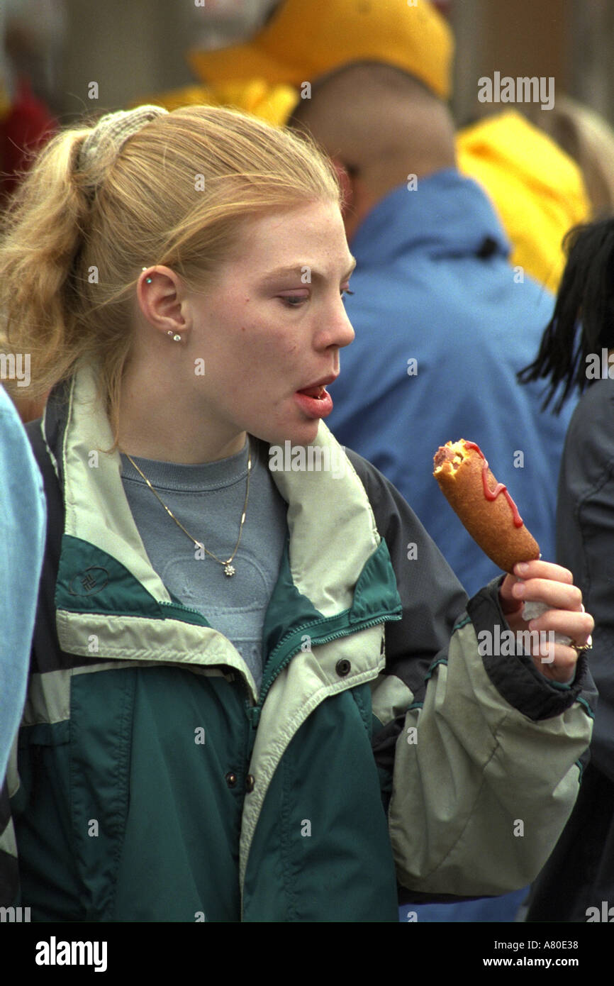 Woman age 20 eating corn dog at Cinco de Mayo parade. St Paul Minnesota ...
