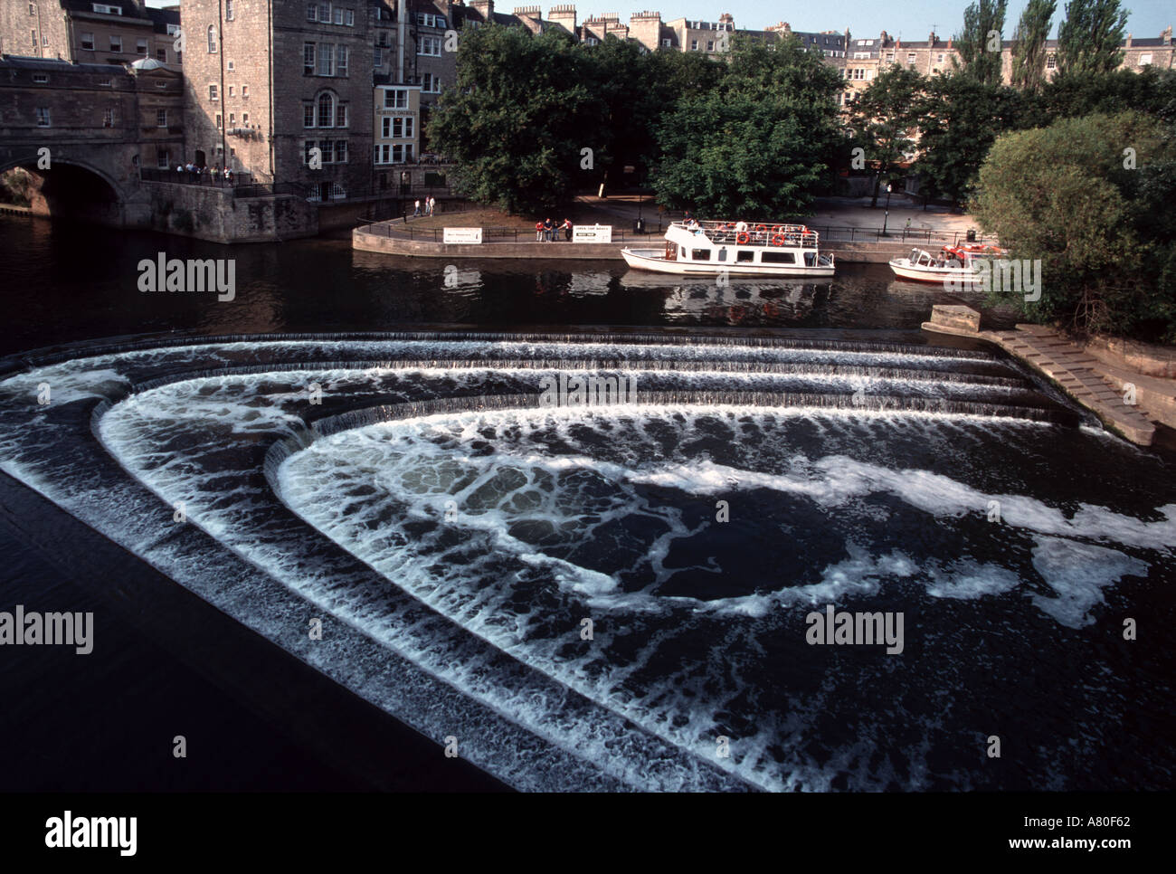 Curved river weir with excursion boat and part of Pulteney Bridge in ...