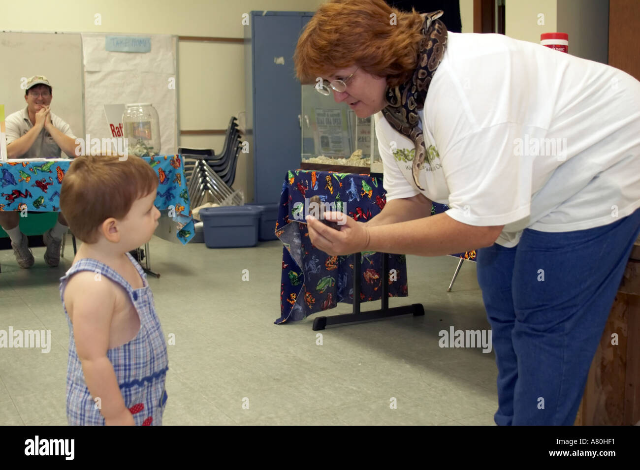 Lady snake owner showing a chuckwalla to a young child while a ball ...