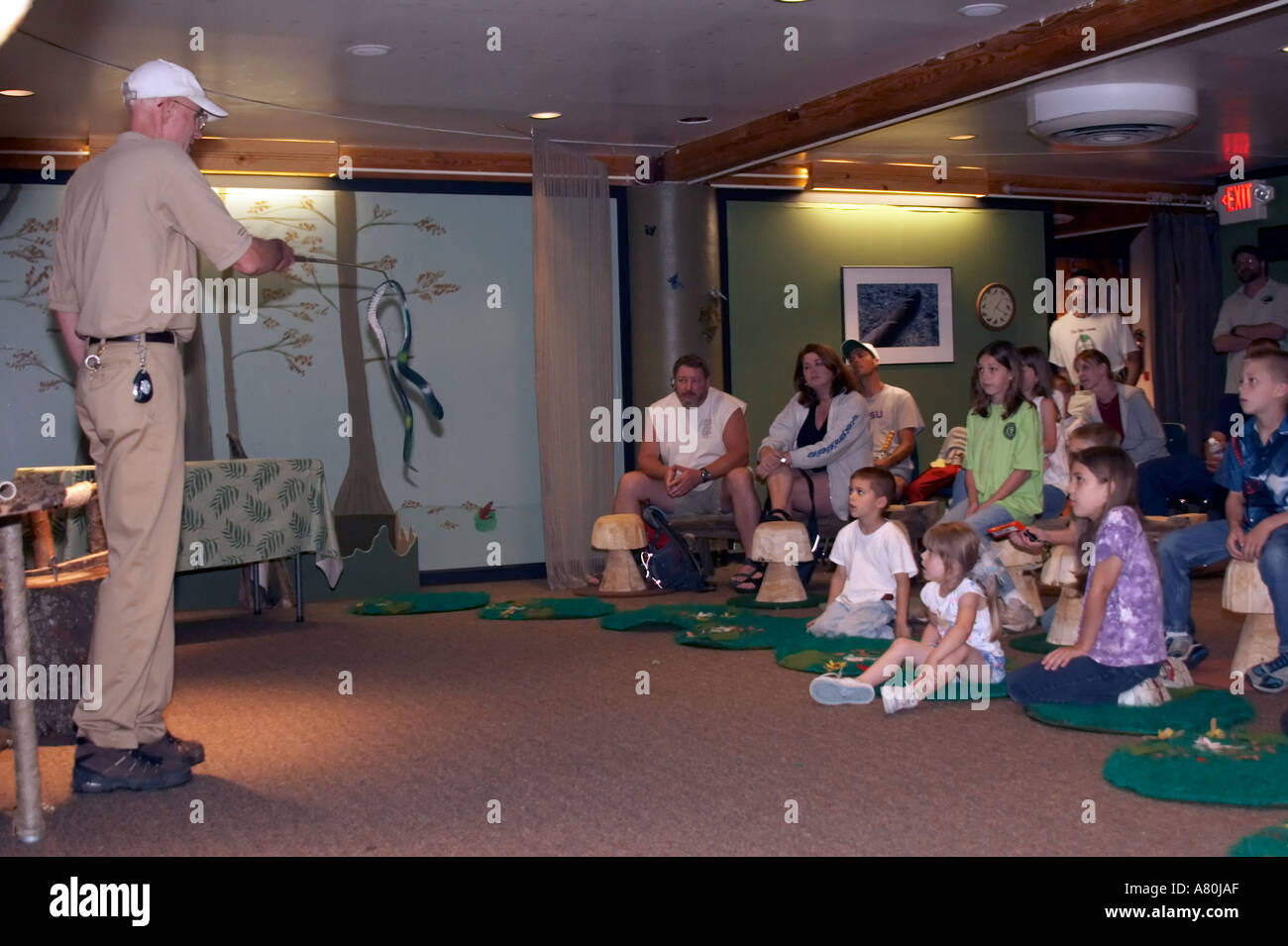 Naturalist snake handler demonstrating techniques to children in a ...