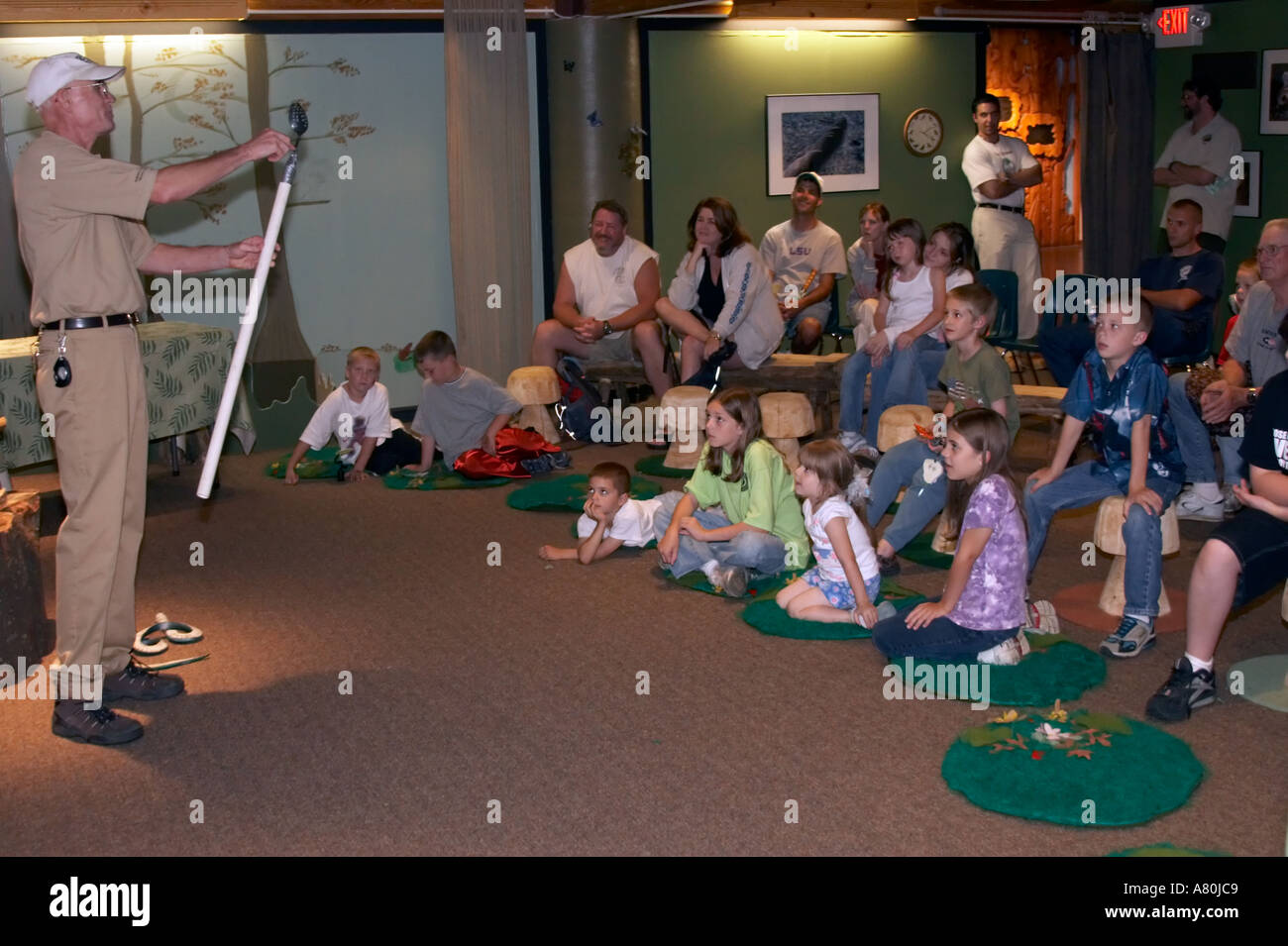 Naturalist snake handler demonstrating techniques to children in a ...