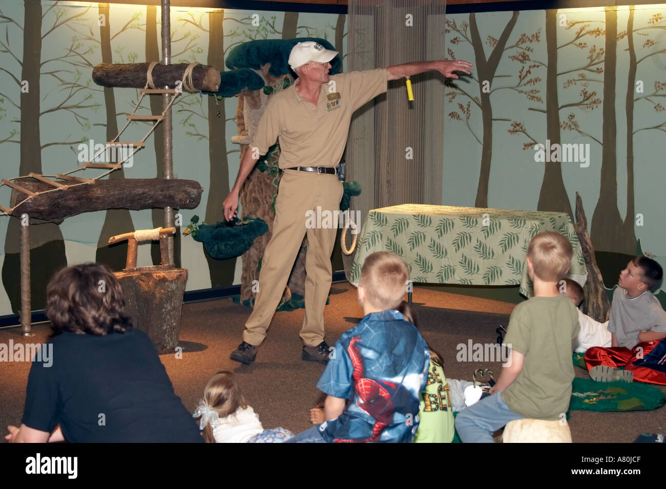 Naturalist snake handler demonstrating techniques to children in a ...