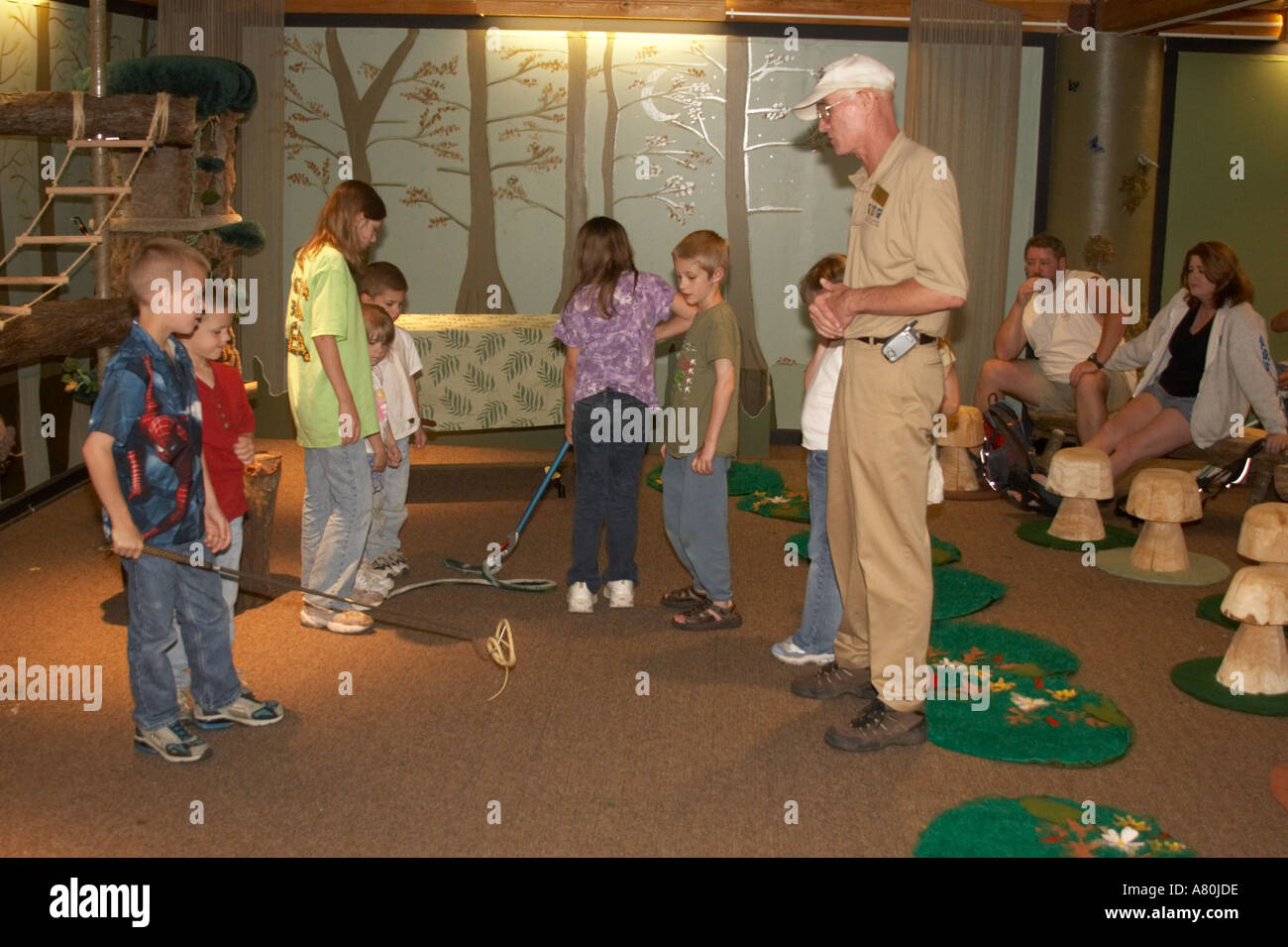 Naturalist snake handler demonstrating techniques to children in a ...