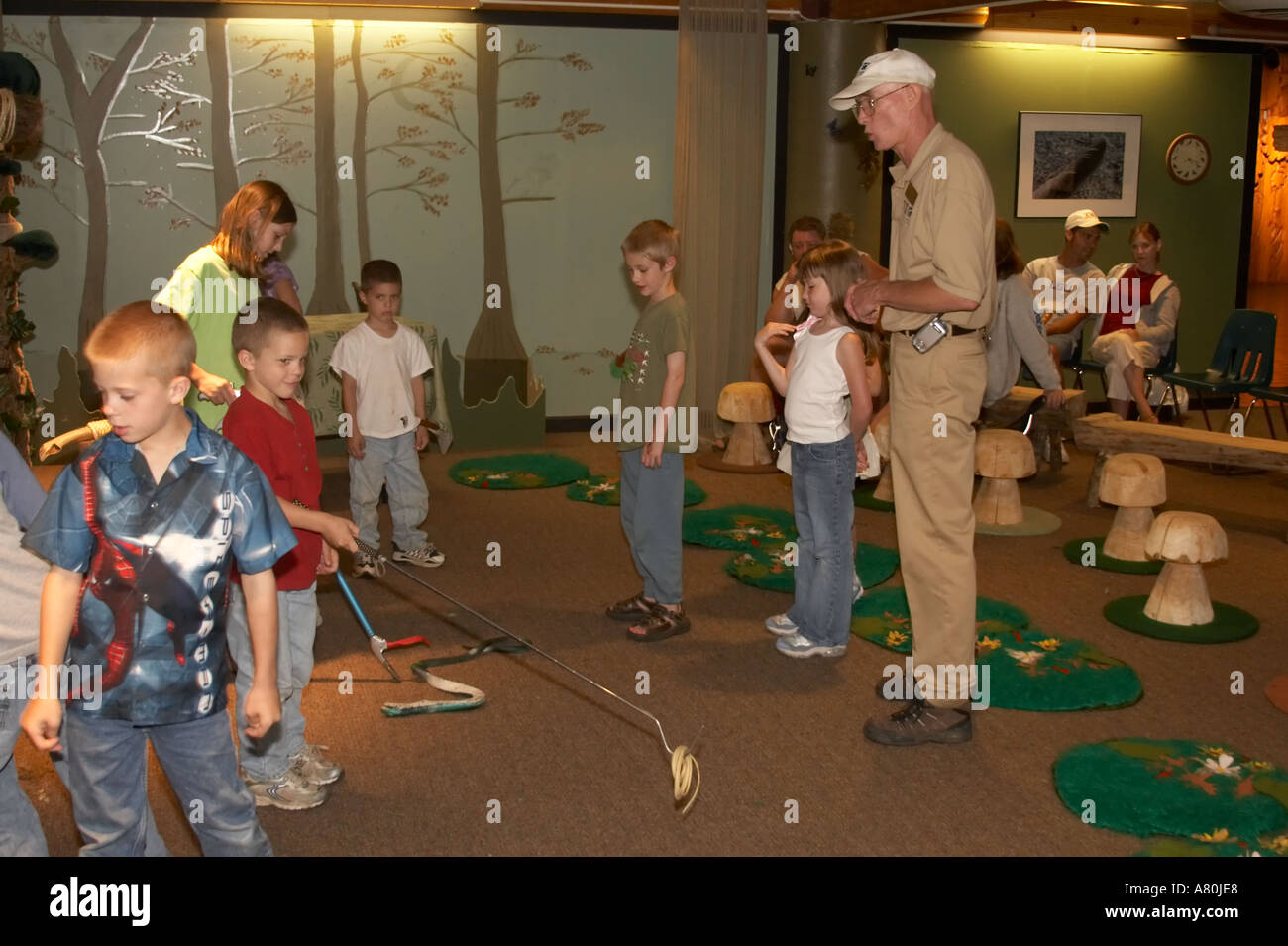 Naturalist snake handler demonstrating techniques to children in a ...
