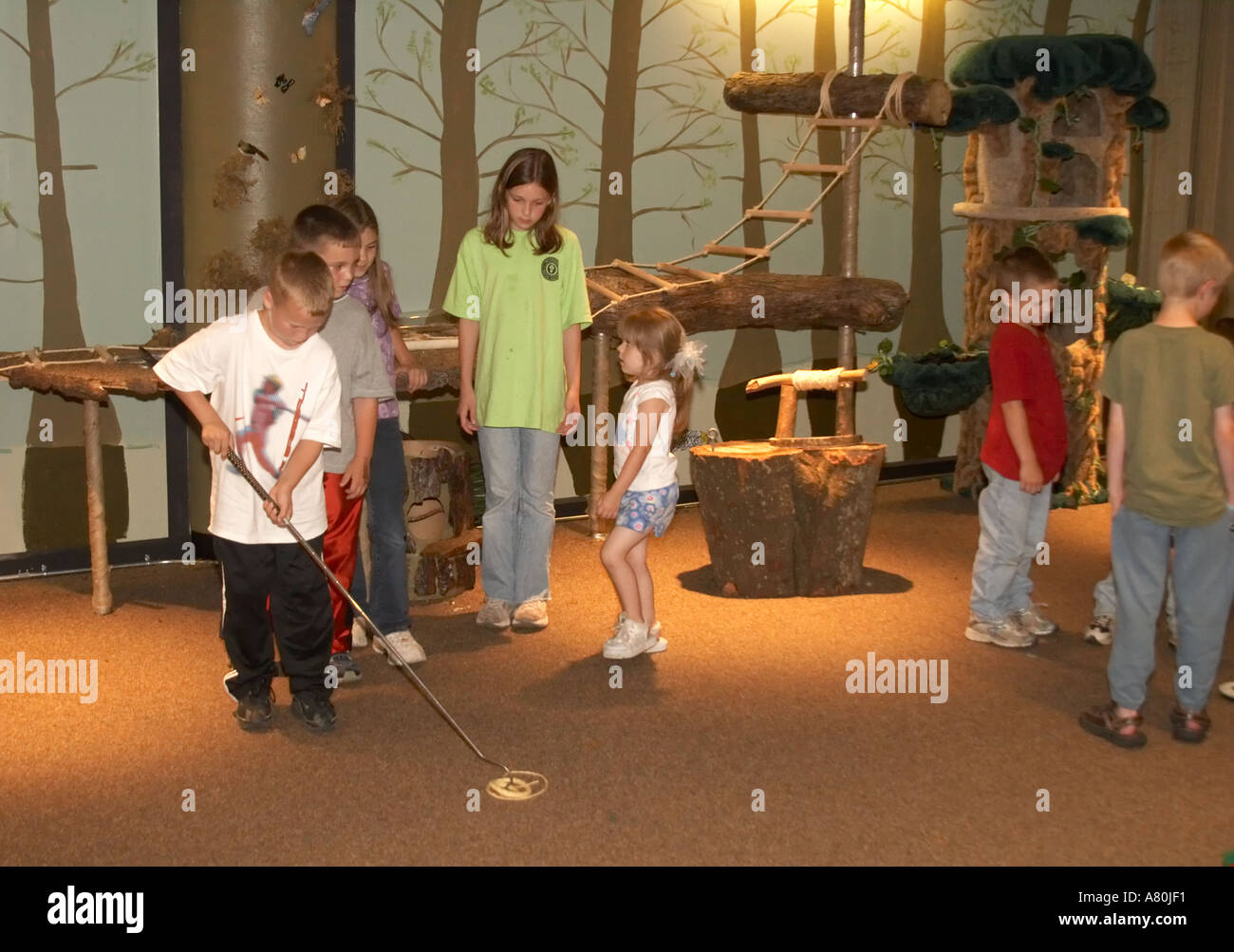 Children practicing snake handling techniques in a nature classroom ...