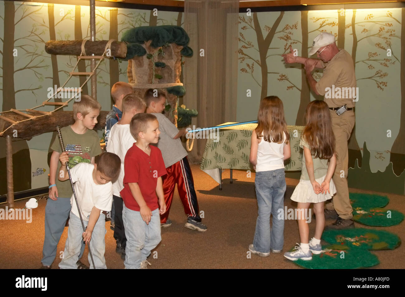 Children practicing snake handling techniques in a nature classroom ...