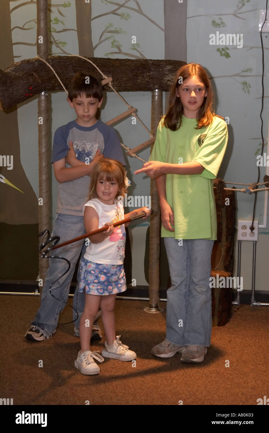 Children practicing snake handling techniques in a nature classroom ...