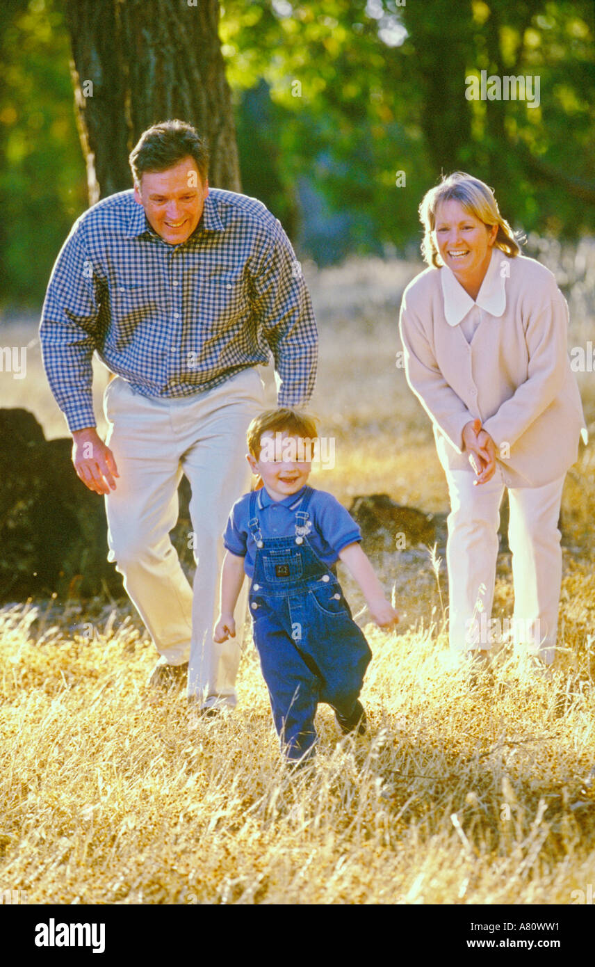 parents and son running across the field Stock Photo - Alamy