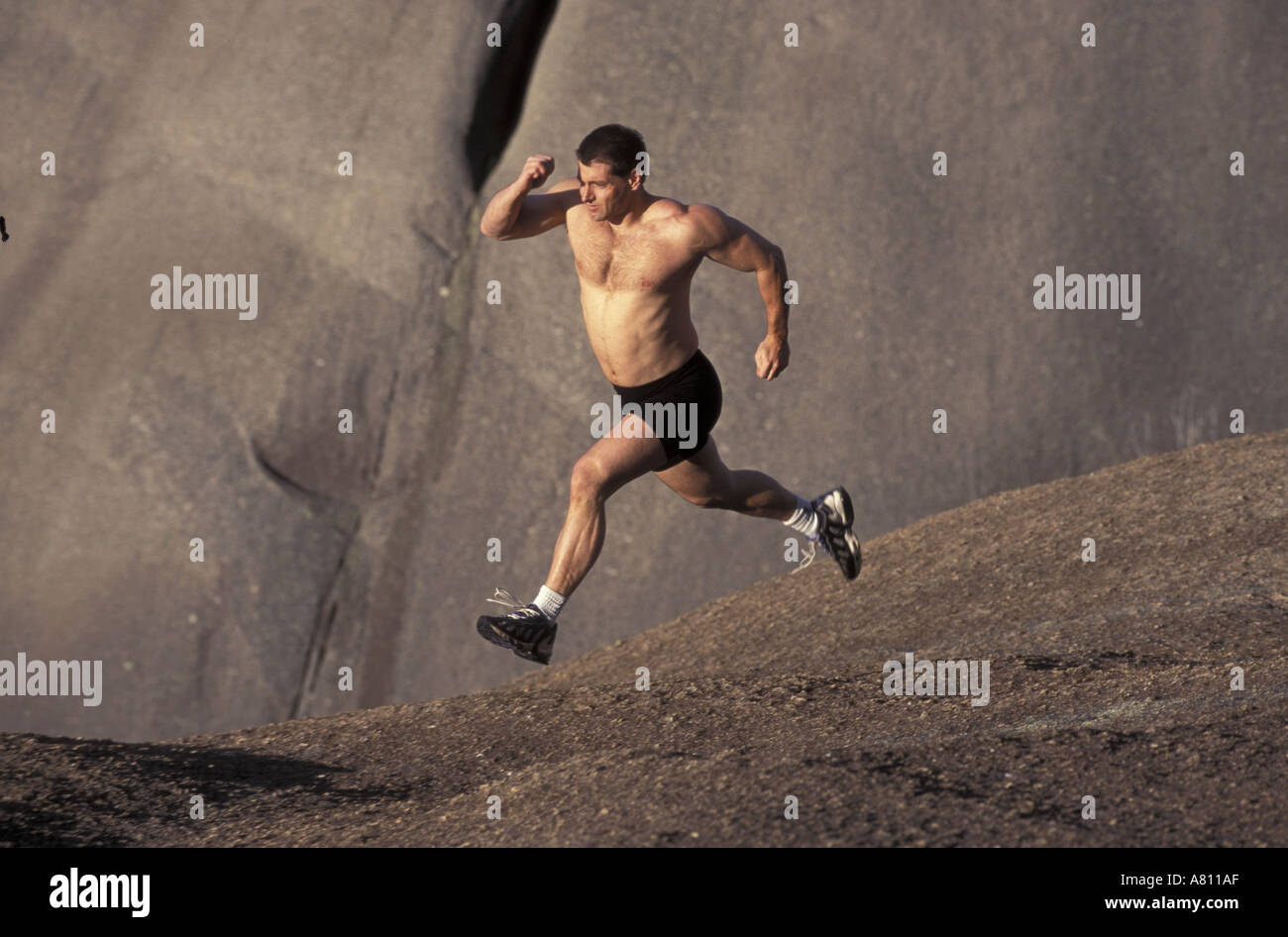 Man running on granite rocks Stock Photo - Alamy