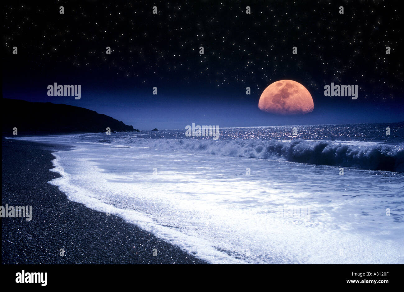 Large moonrise over waves breaking on deserted beach with star lit sky ...