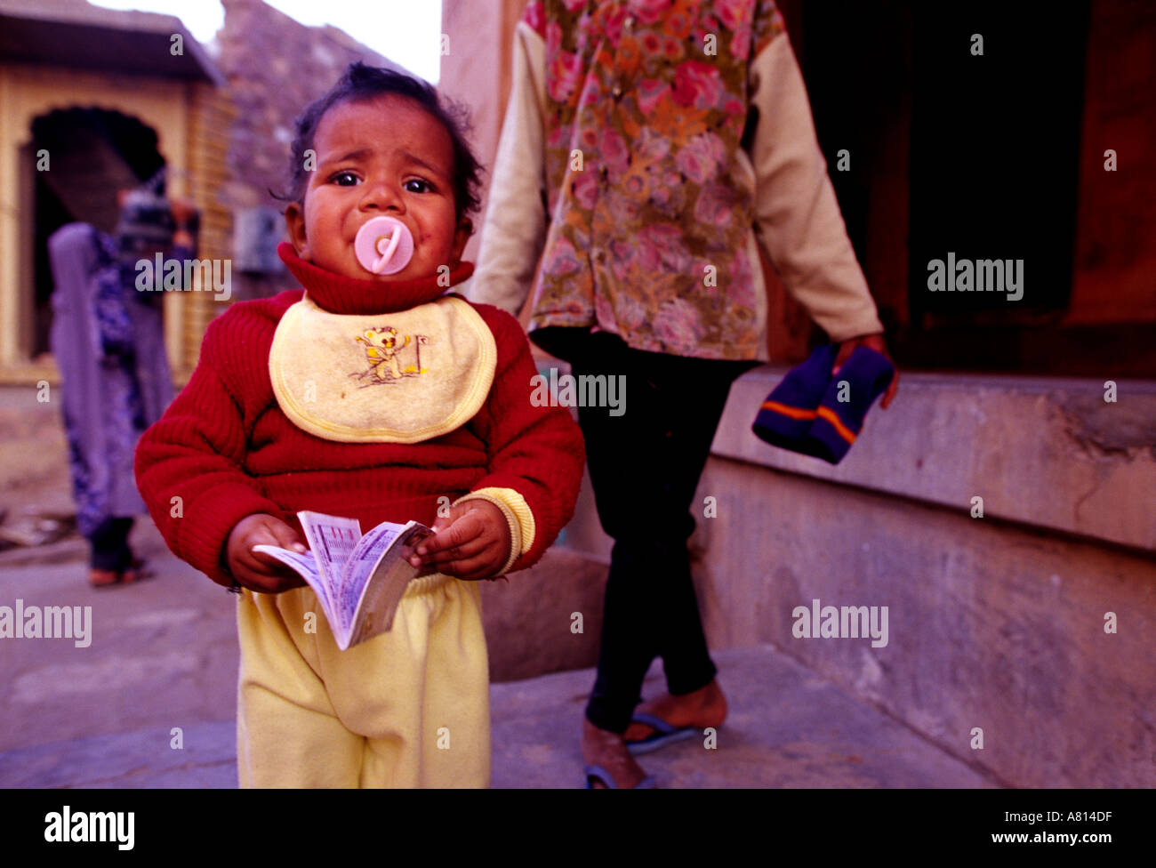 Young child with dummy and book Stock Photo - Alamy