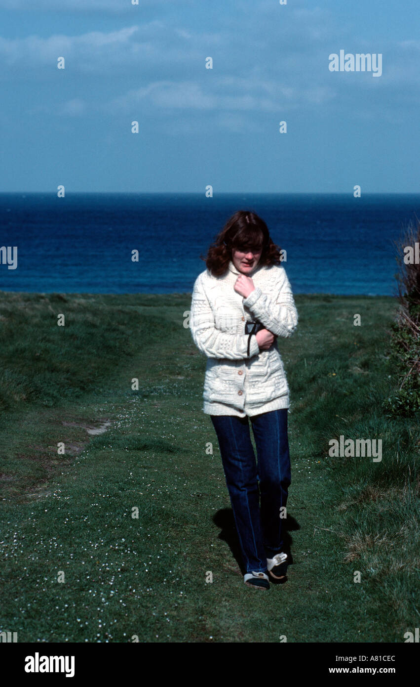 Young woman walking on a windy cliff top Stock Photo - Alamy
