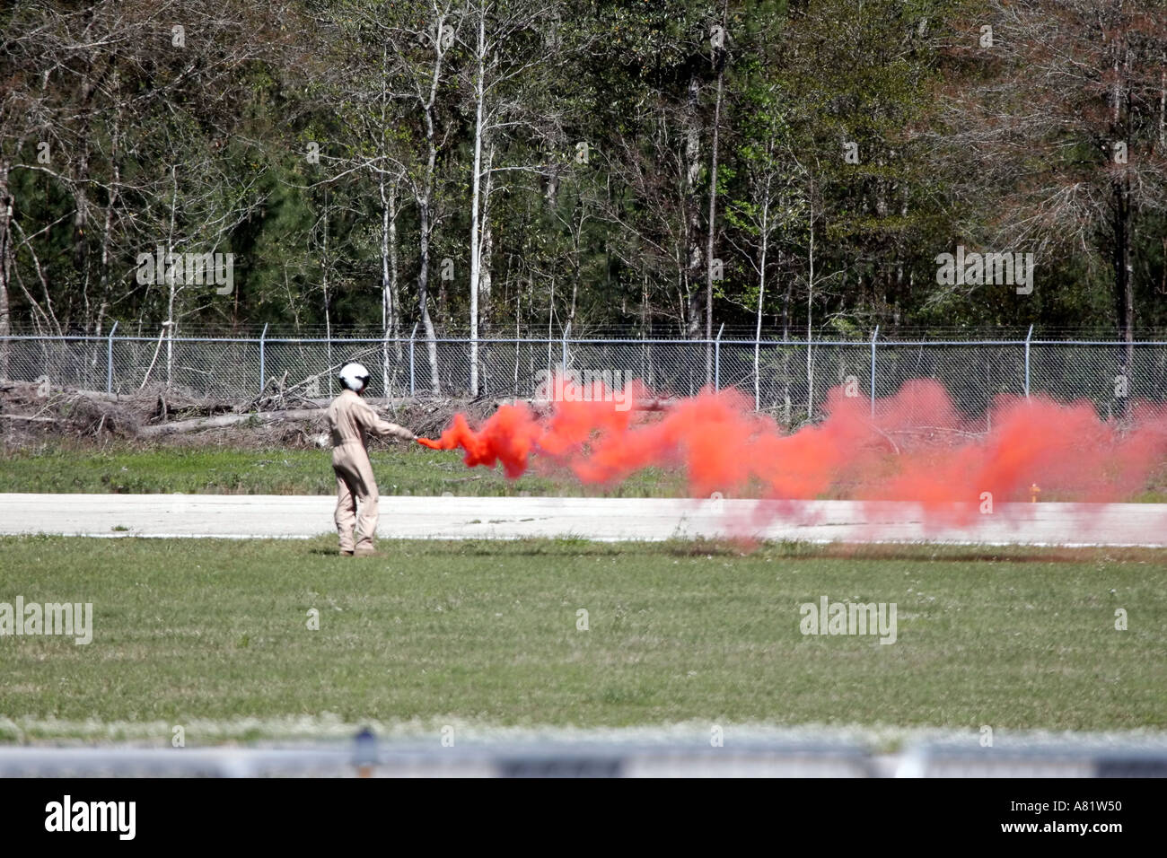 A coast guard crewman ignites a smoke marker during a search and ...