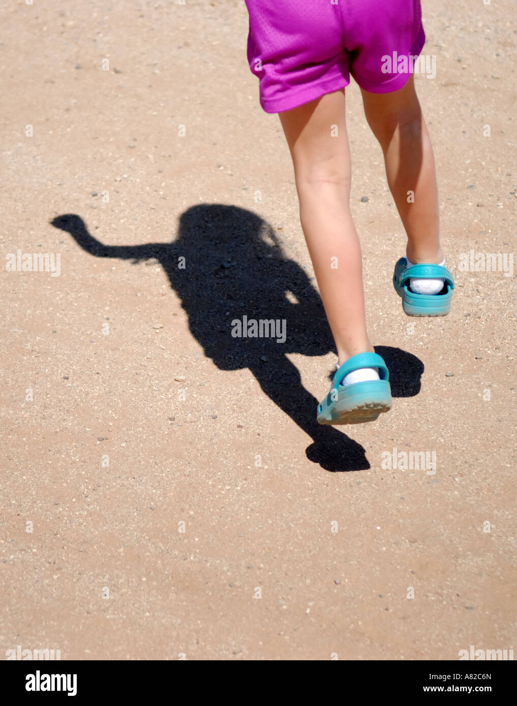 Shadow on ground of young girl skipping Stock Photo - Alamy