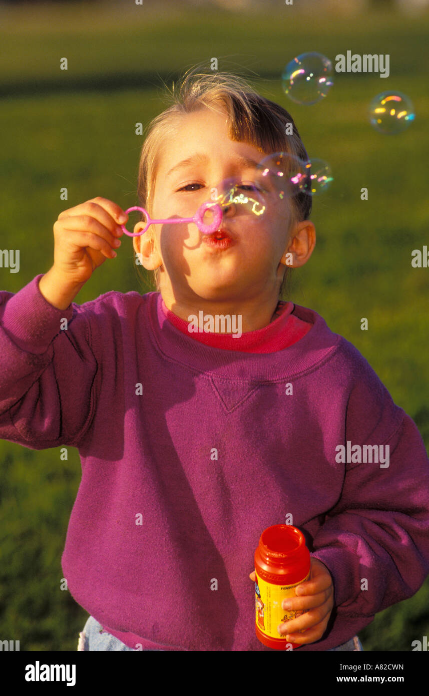 Child age 3 blowing soap bubbles at the park Ventura California Stock ...