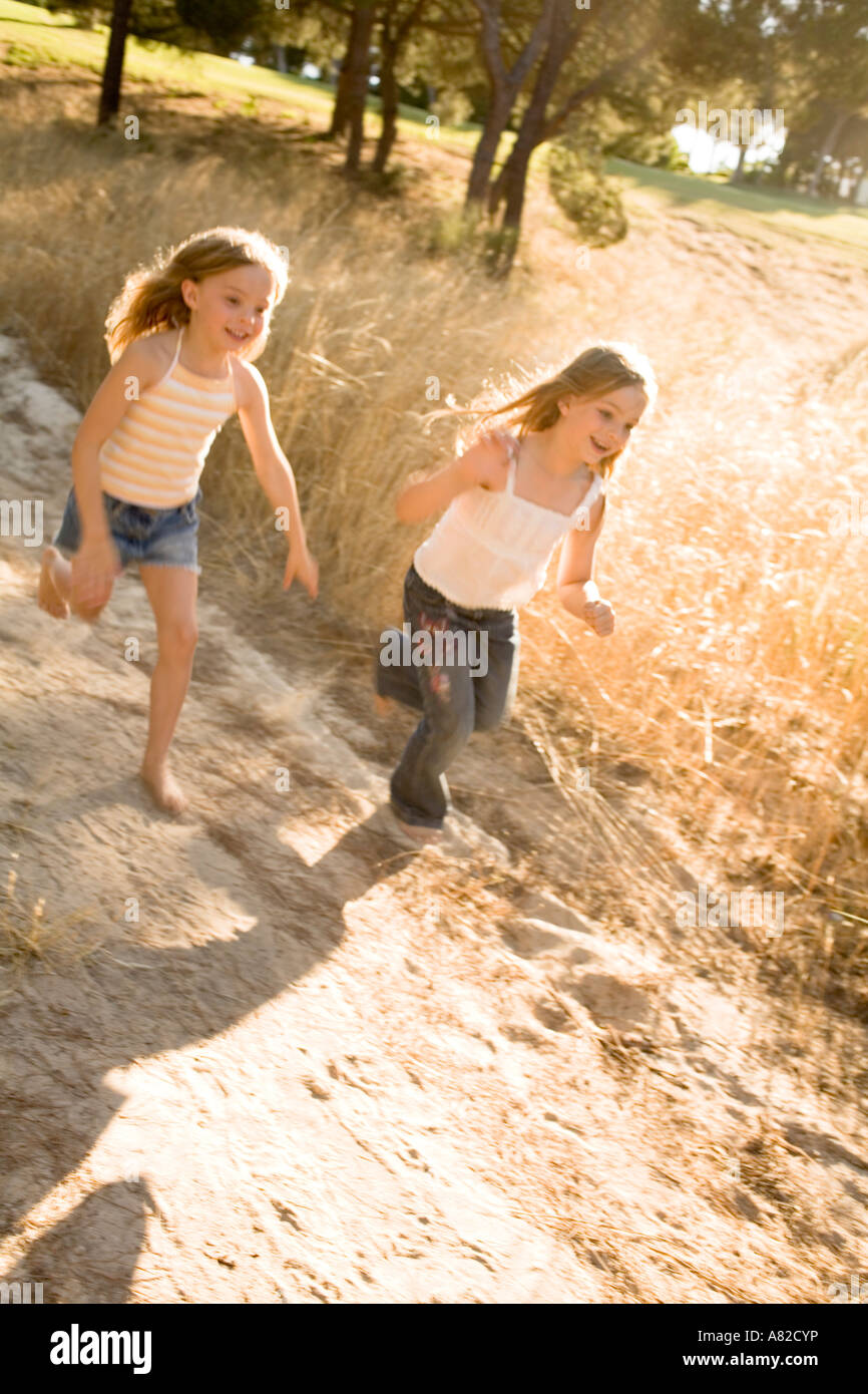 Two girls running down a path Stock Photo - Alamy