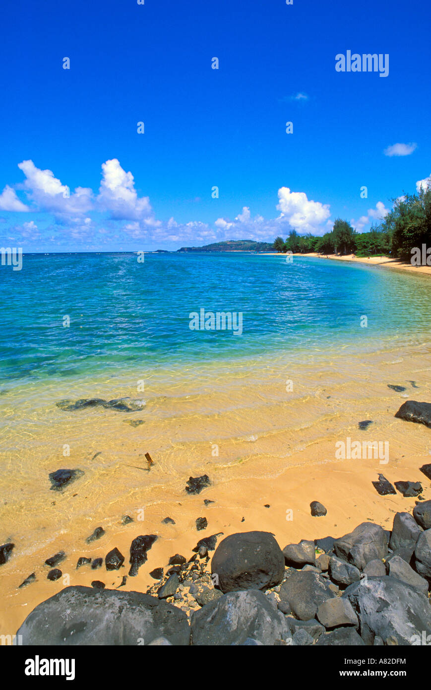 Blue Pacific waters and white sand at Anini Beach North Shore Island of ...