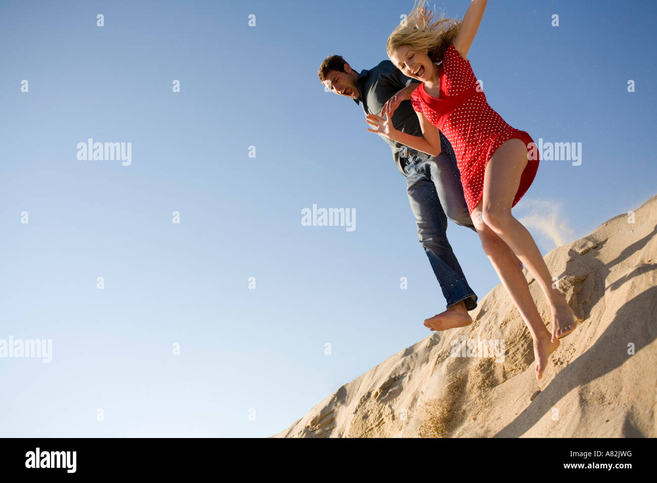 Young couple jumping off sand dune hi-res stock photography and images ...