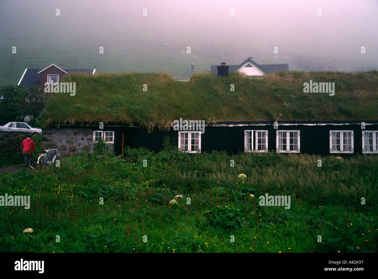 Faroe Islands woman walking between houses in Skalavik Stock Photo - Alamy