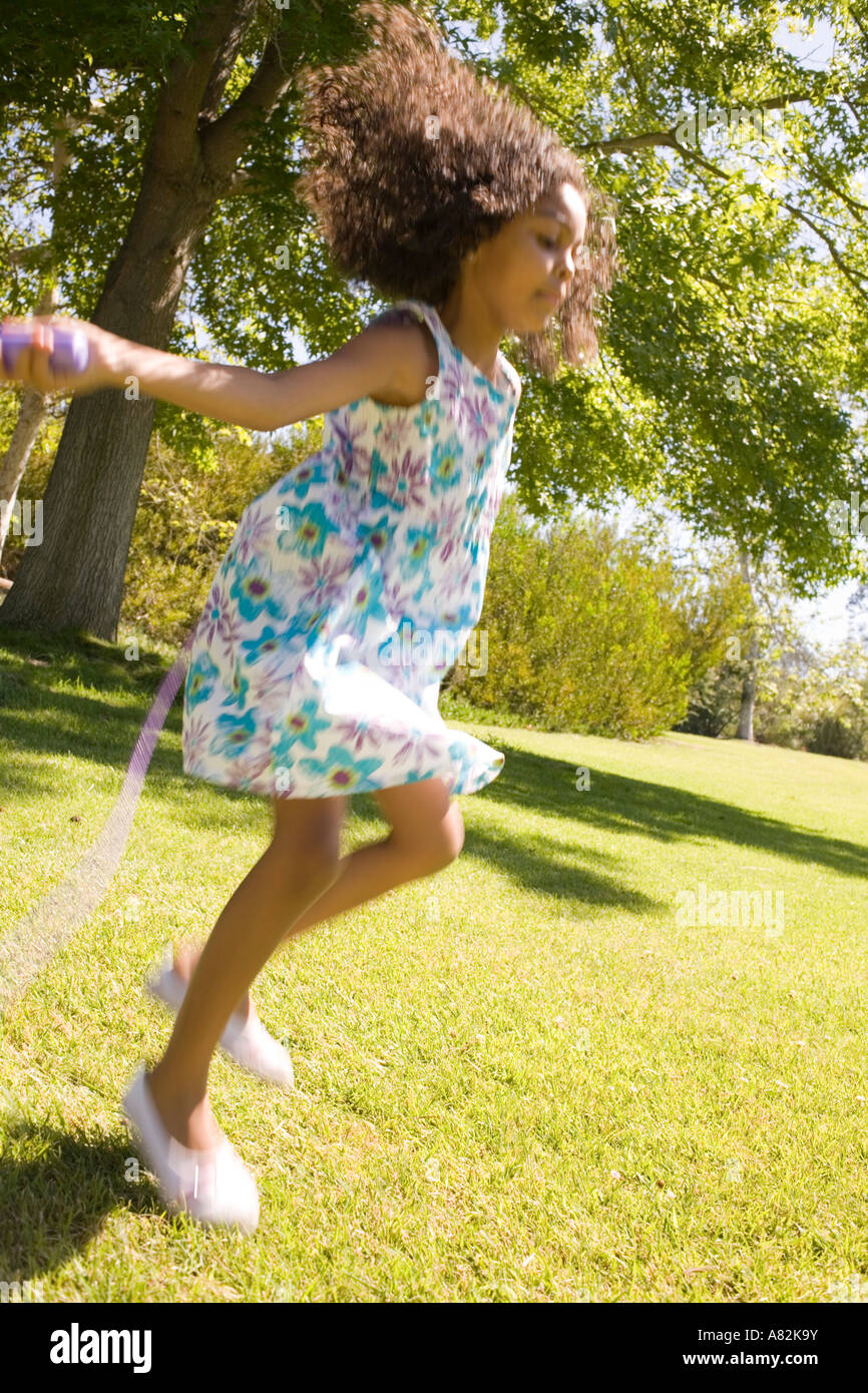 A girl in a park skipping rope Stock Photo - Alamy