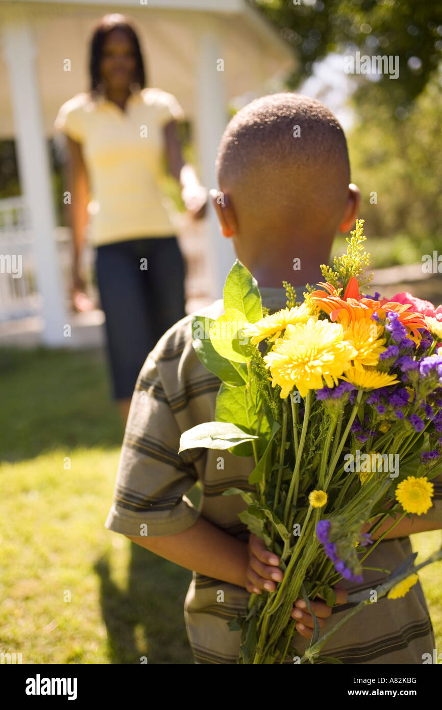 A boy giving his mother flowers Stock Photo - Alamy