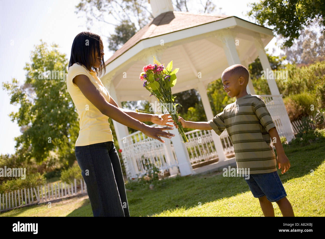 A boy giving his mother flowers Stock Photo - Alamy
